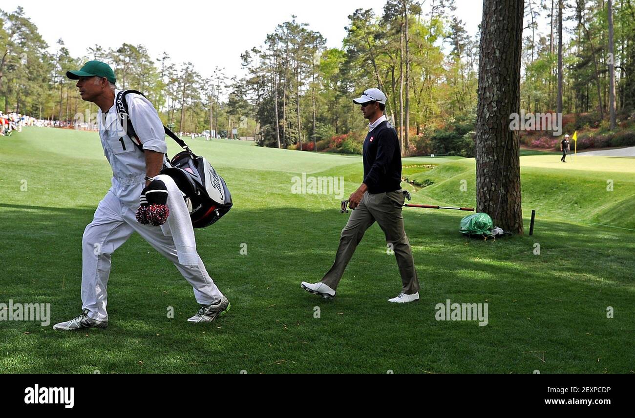 Caddie Steve Williams and golfer Adam Scott walk to the 14th tee box ...