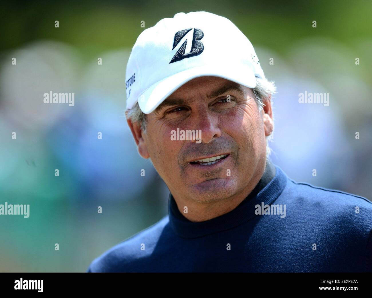 Fred Couples speaks with his caddie on the putting green during a ...