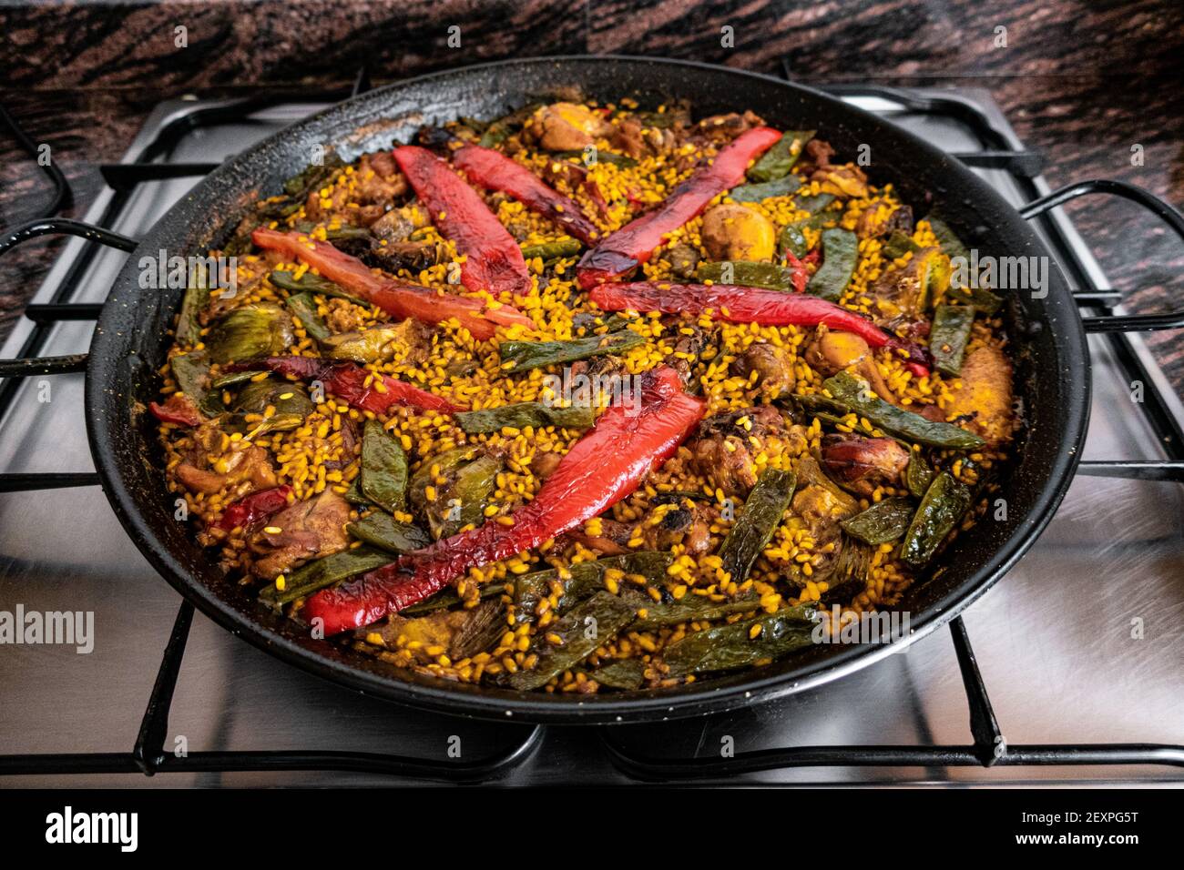 A beautiful shot of a Spanish rice dish named Paella on a gas stove ...