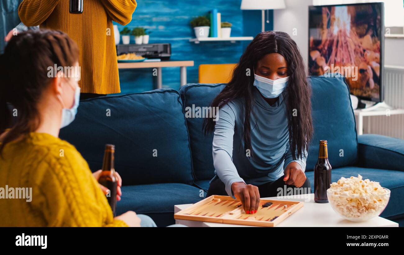 Group of cheerful multiethnic friends playing board games backgammon ...