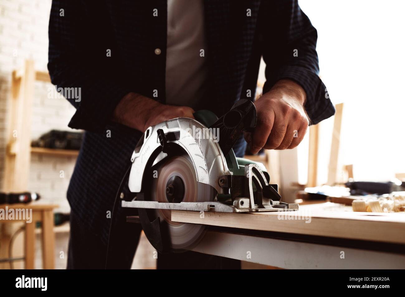 Carpenter hands cutting wood with electrical saw Stock Photo - Alamy