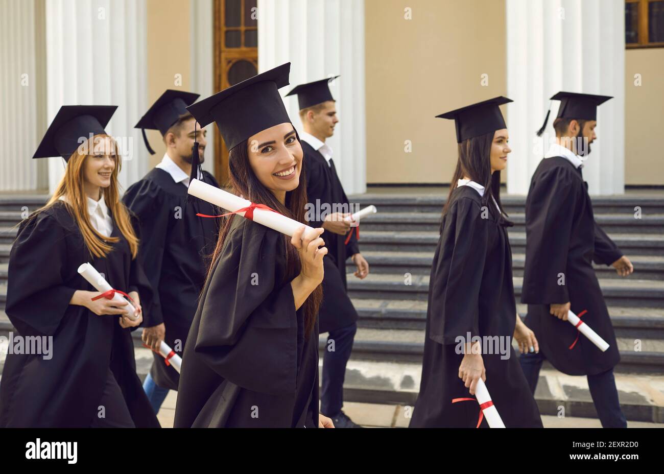 Group of young happy university graduates mates walking with diplomas ...