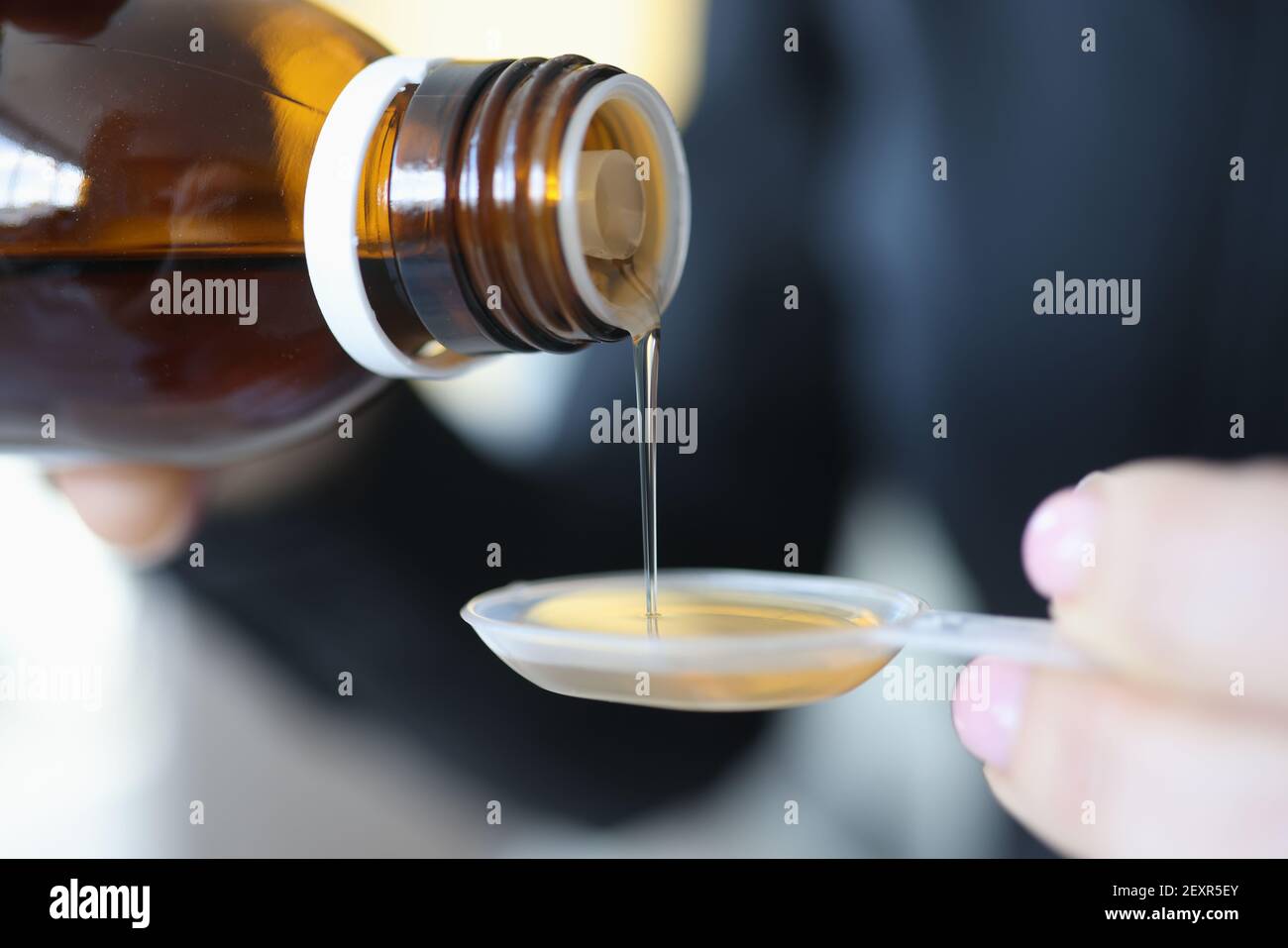 Woman pouring medicinal syrup into measuring spoon closeup Stock Photo ...