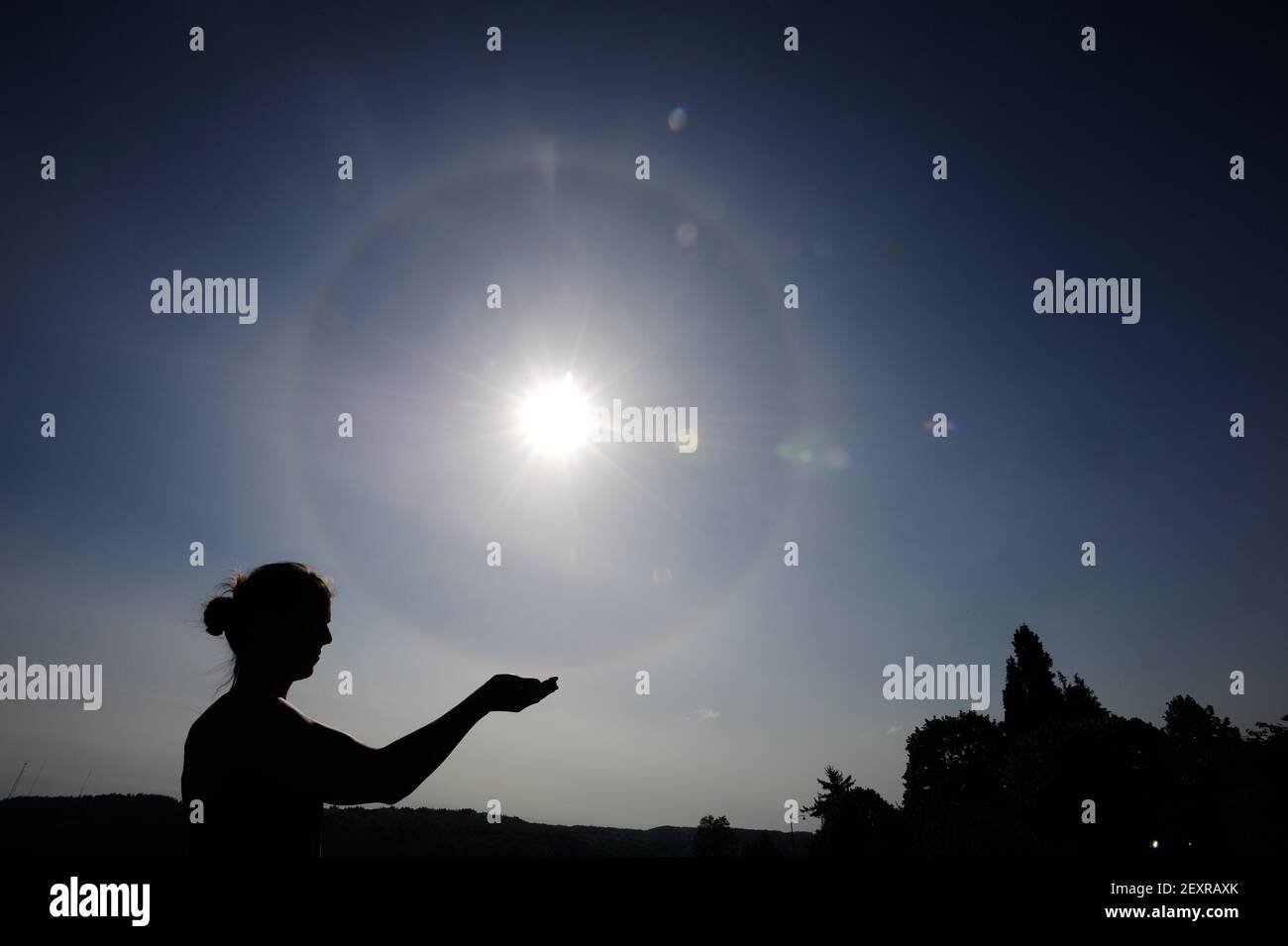 Kimberley Daglen appears to hold up the solar halo viewed over North ...