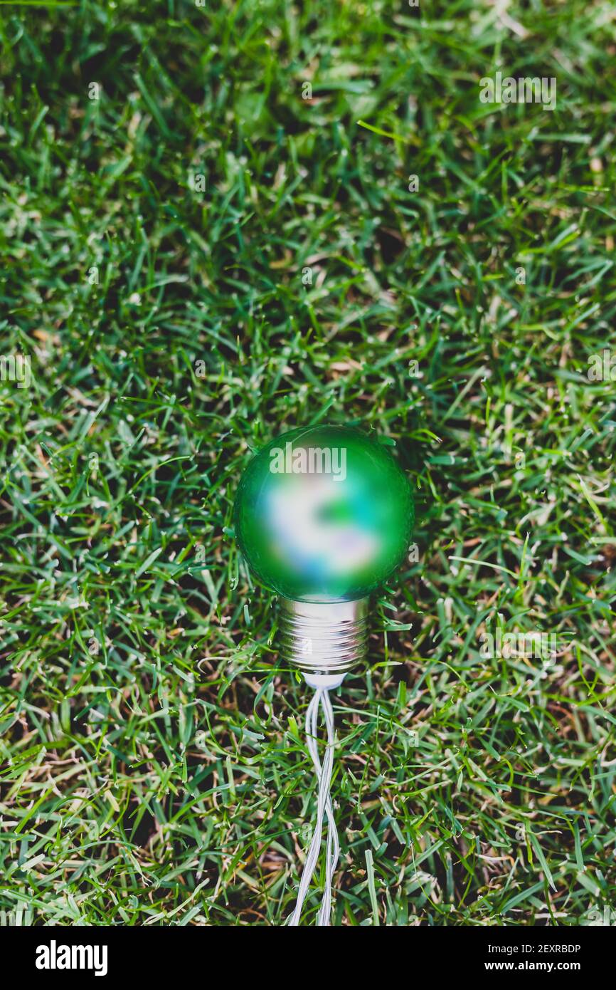 green light bulb on perfect green grass lawn, ecology and ...