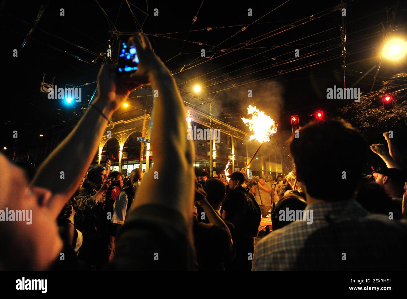 Anti-capitalist protesters light a trash can on fire in the street ...