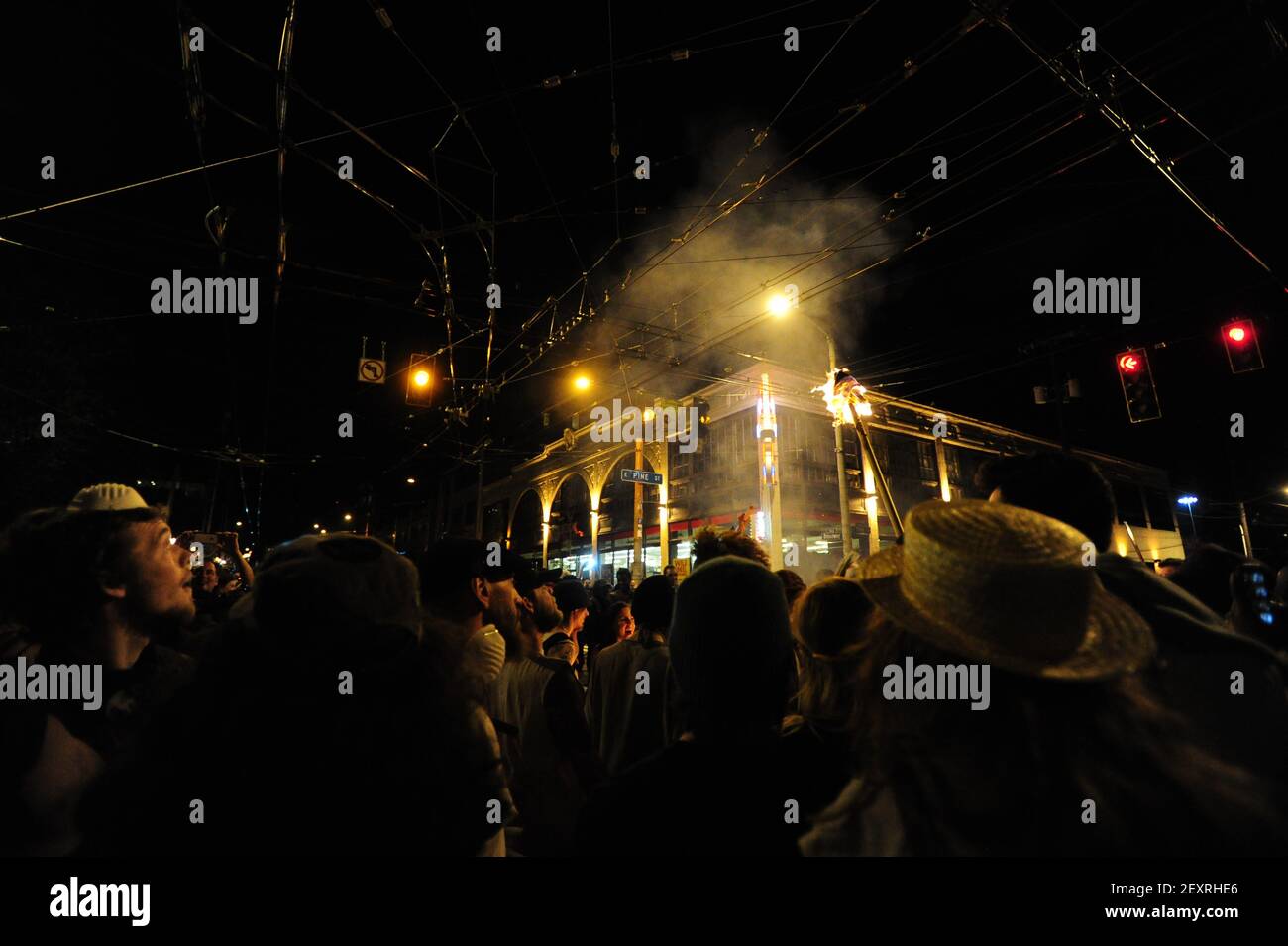 Anti-capitalist protesters light a trash can on fire in the street ...