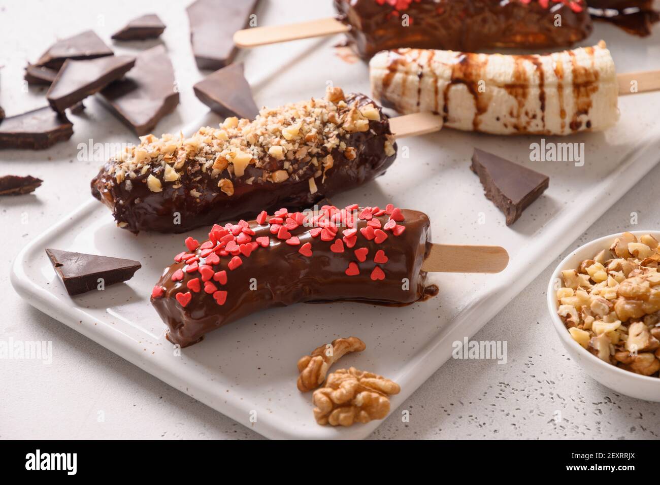 Frozen banana lollipops or lollies with walnuts sprinkles for kids on ...