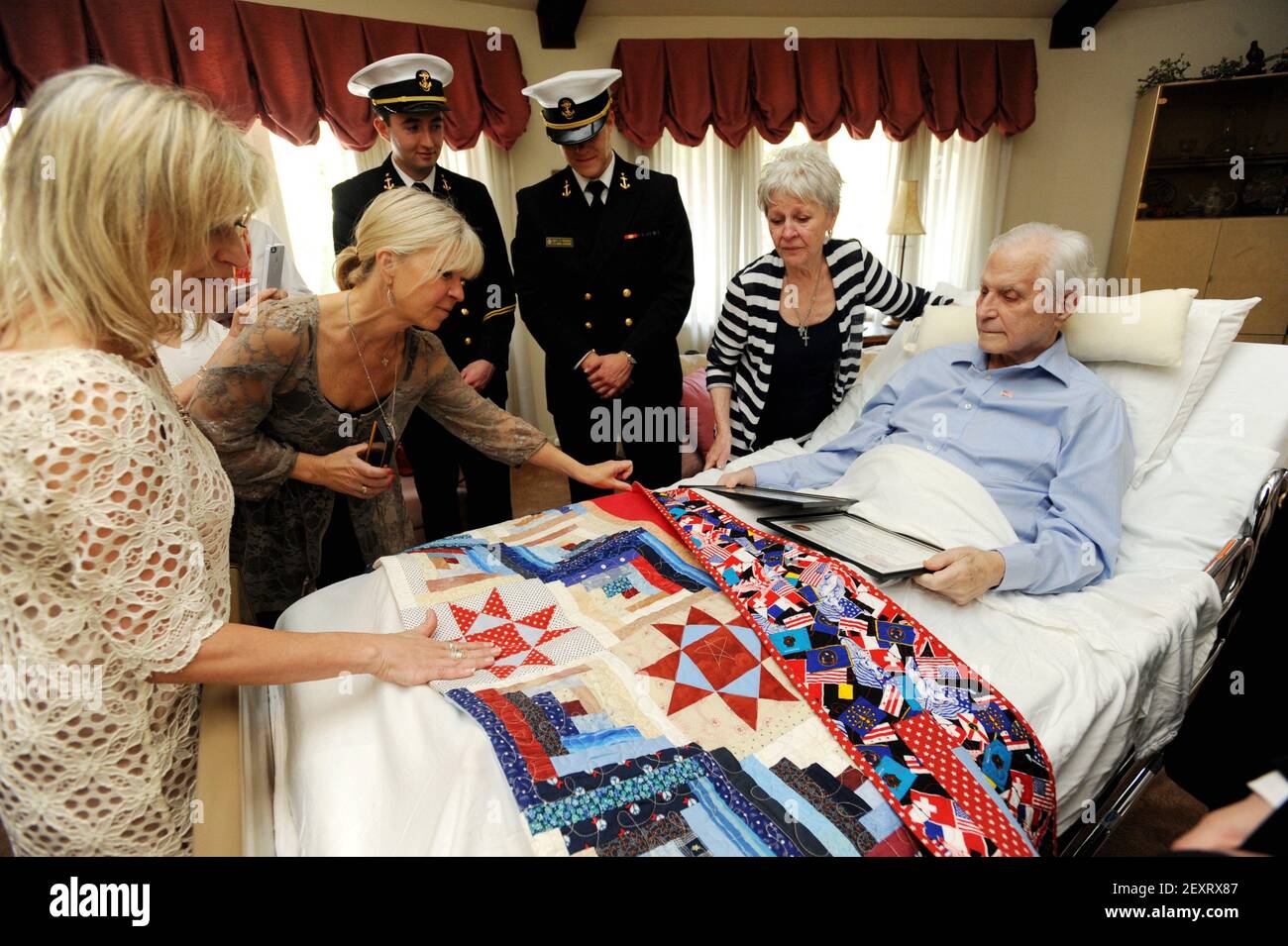 Diane Gray, from left, Deborah Rolig, look at a quilt presented to ...