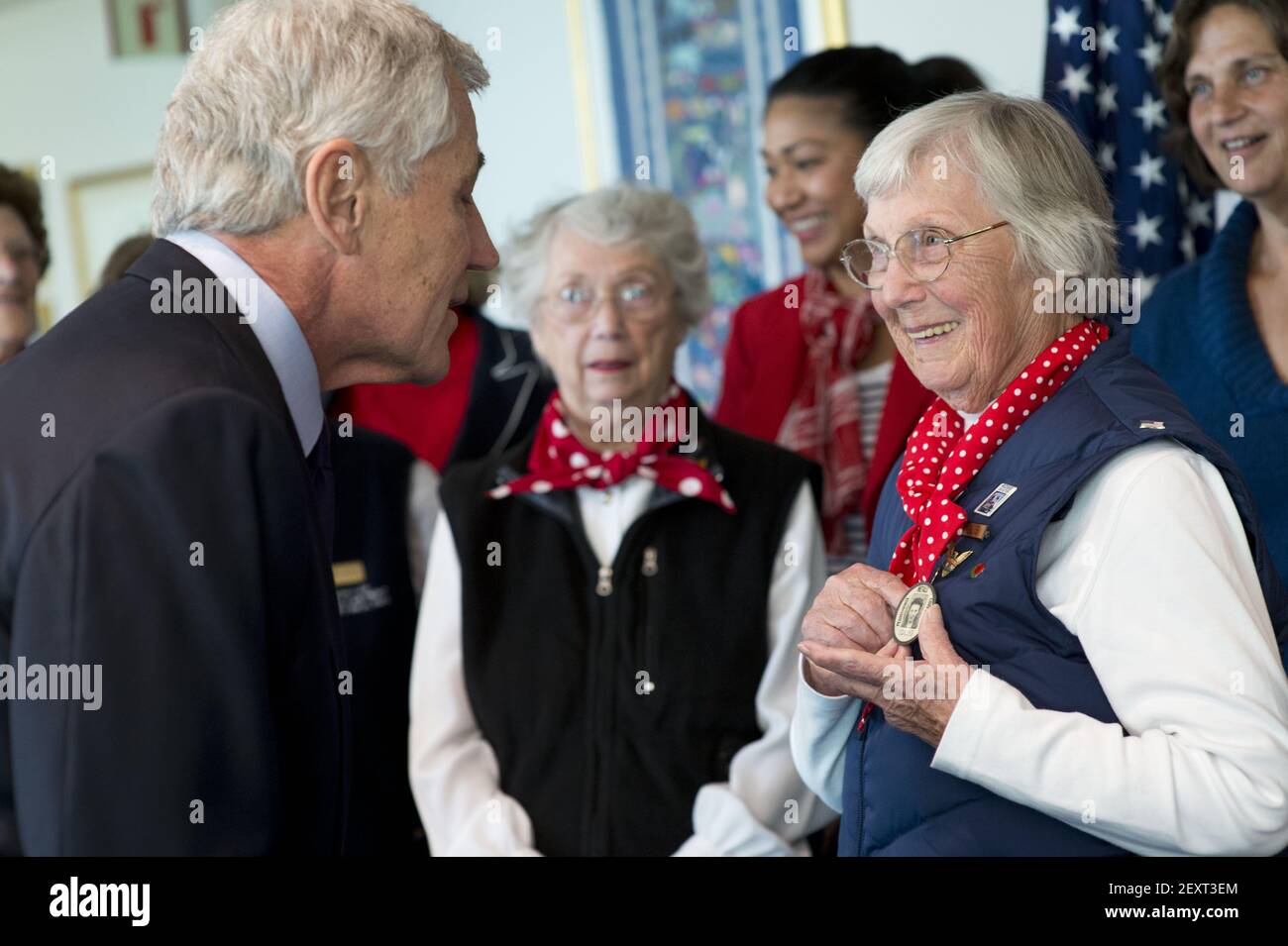Secretary of Defense Chuck Hagel is shown a badge by Phyllis Gould that ...