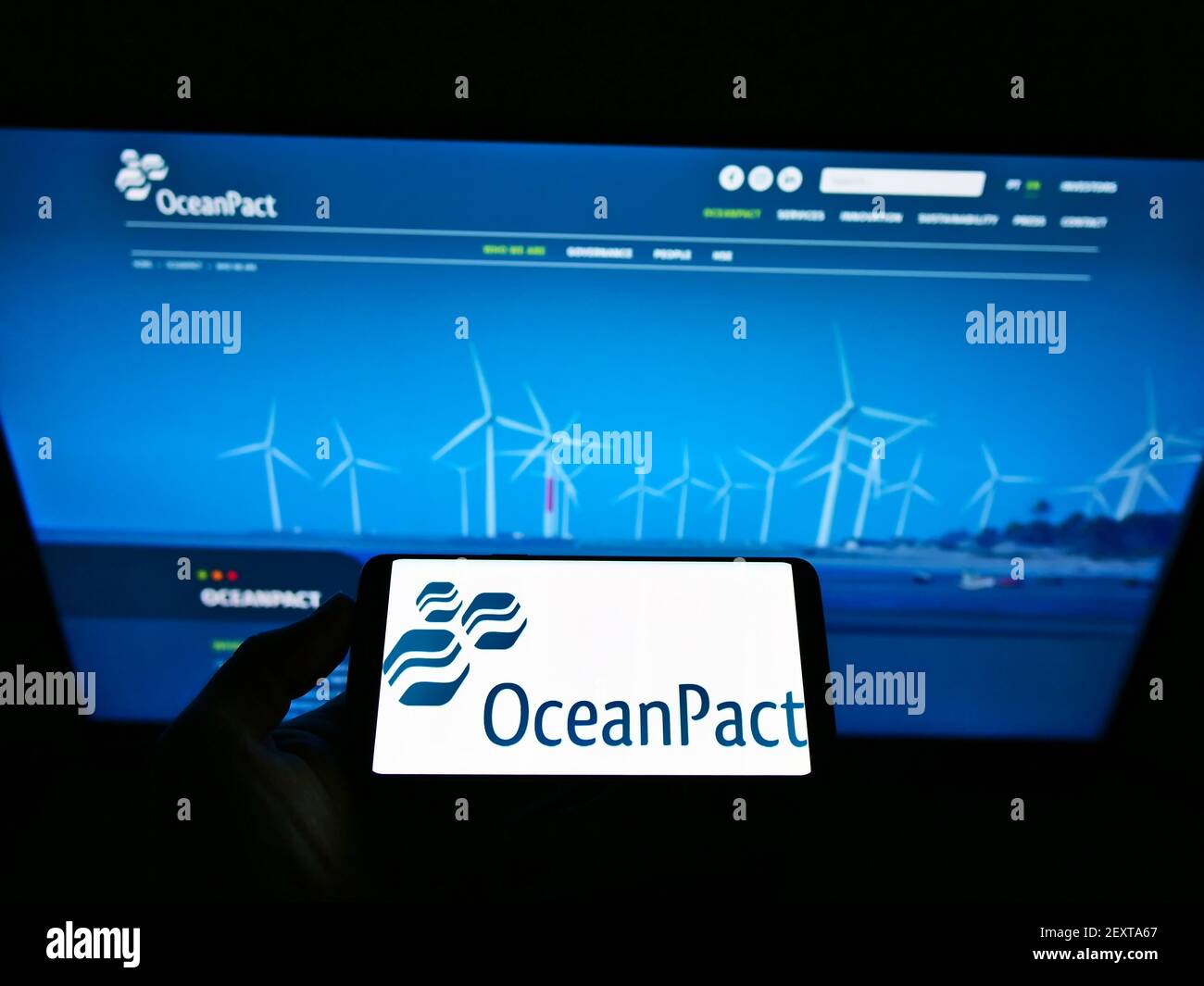 Person holding mobile phone with logo of Brazilian company OceanPact ...