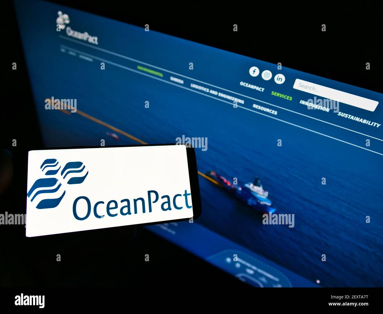 Person holding smartphone with logo of Brazilian company OceanPact ...