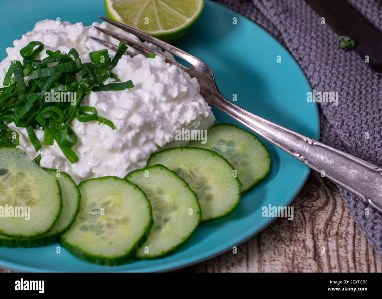 Cottage cheese with spring onions and sliced cucumber on a climate ...