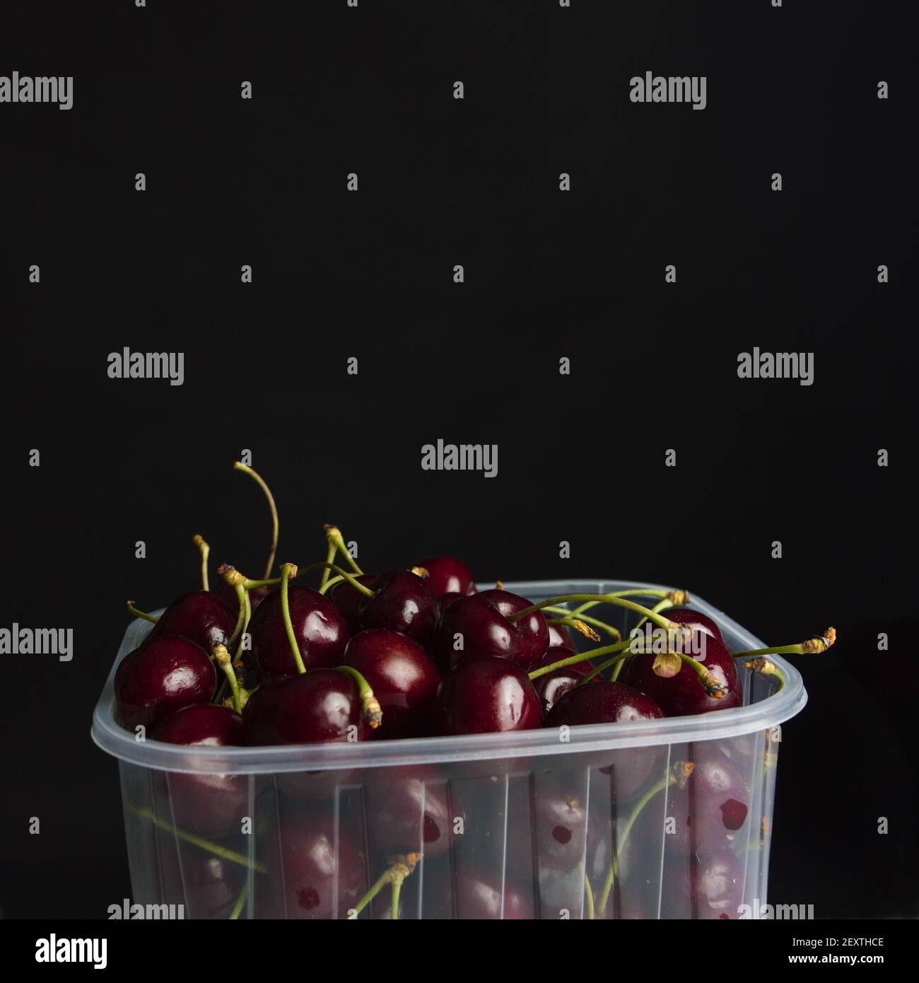 A closeup shot of delicious cherries in a plastic container isolated on ...