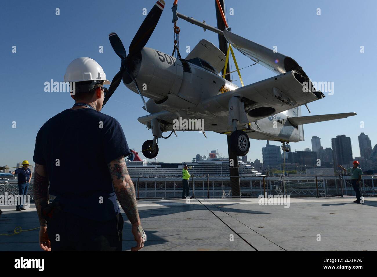 A Douglas A-1 Skyraider is moved onto the flight deck of the Intrepid ...
