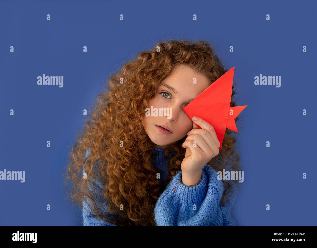 healthy eye of a teenager less-haired girl, origami fish closes its ...