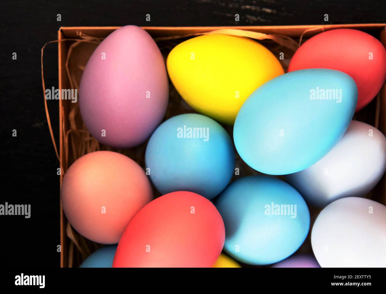 multi color eggs in box on black background Stock Photo - Alamy
