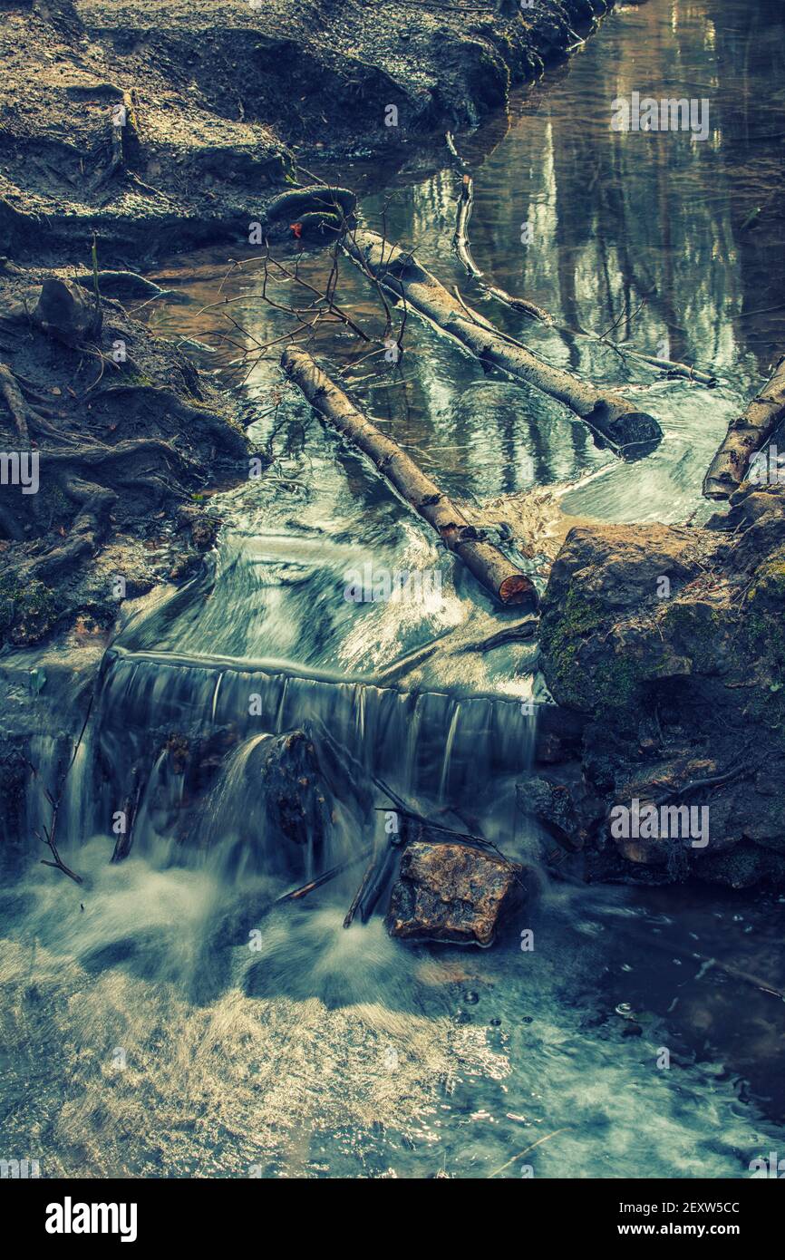 Intimate landscape of stream rushing over a waterfall in a woodland ...