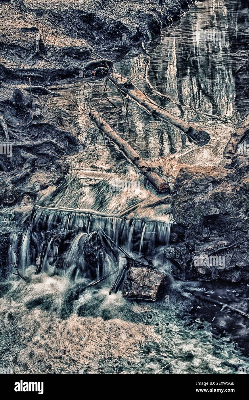 Intimate landscape of stream rushing over a waterfall in a woodland ...