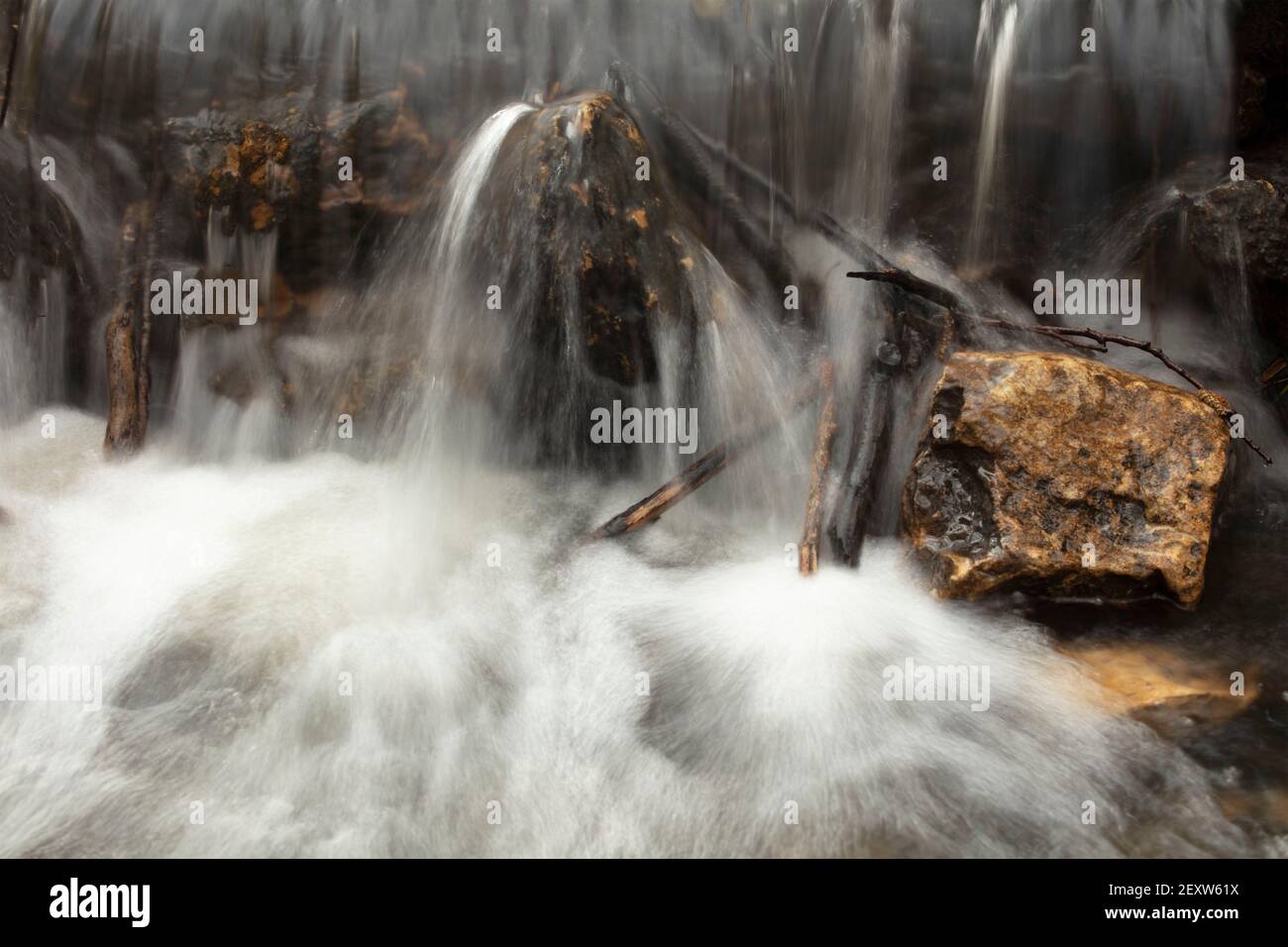 Intimate landscape of stream rushing over a waterfall in a woodland ...