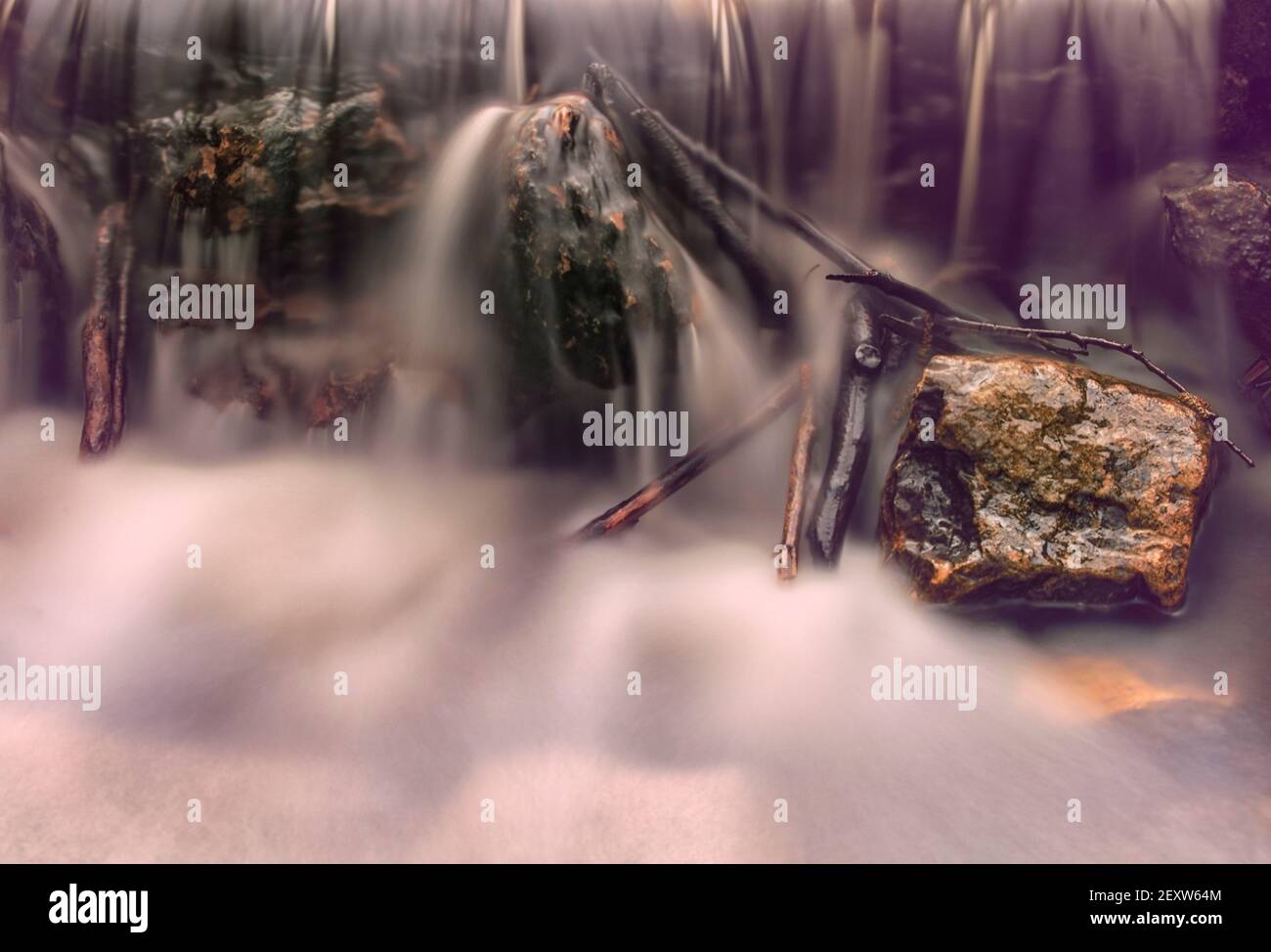 Intimate landscape of stream rushing over a waterfall in a woodland ...