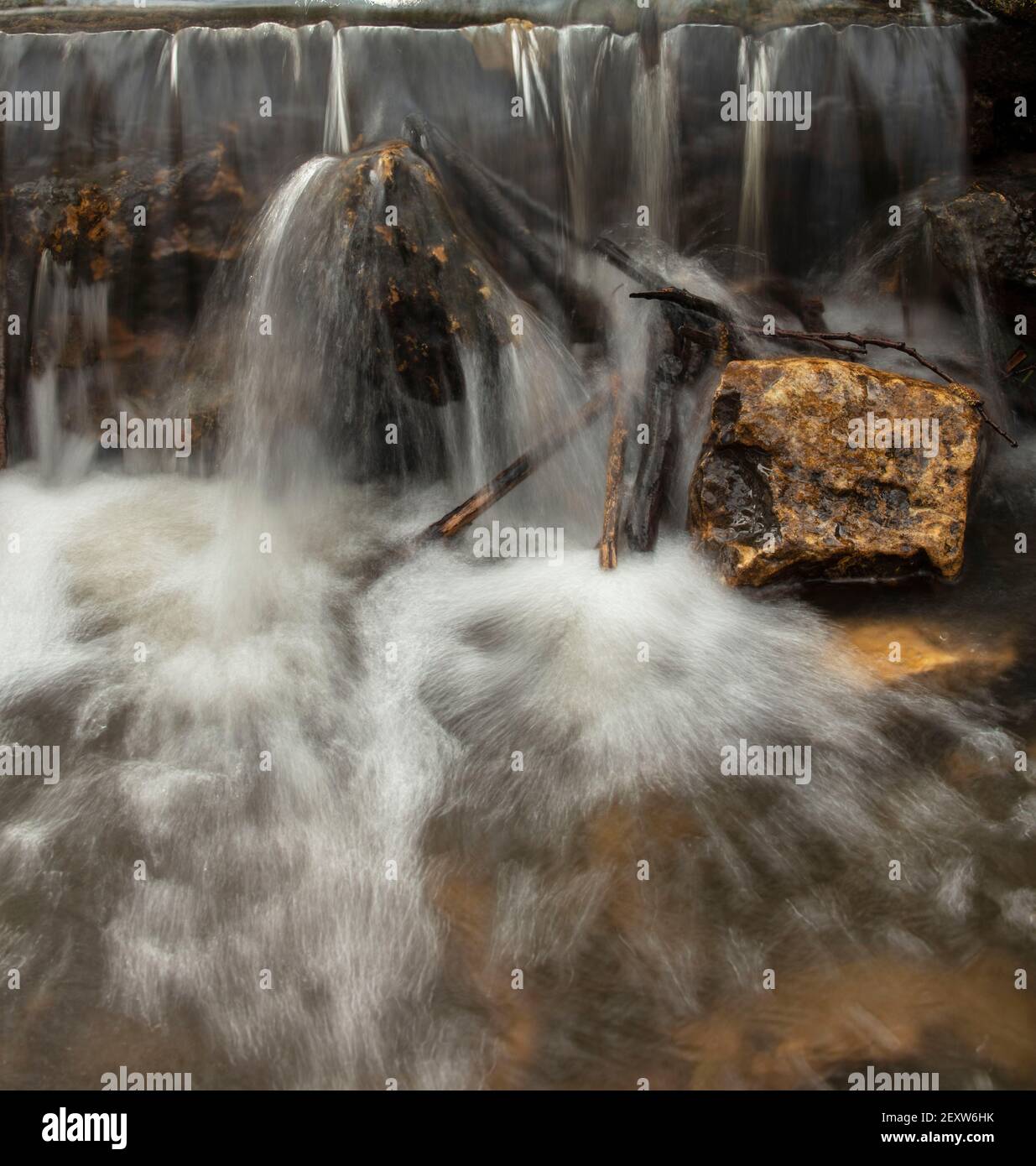 Intimate landscape of stream rushing over a waterfall in a woodland ...