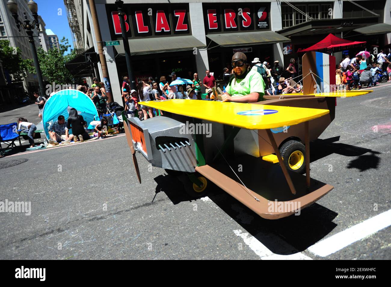 A man drives a biplane down SW 4th Avenue at the end of the Grand ...