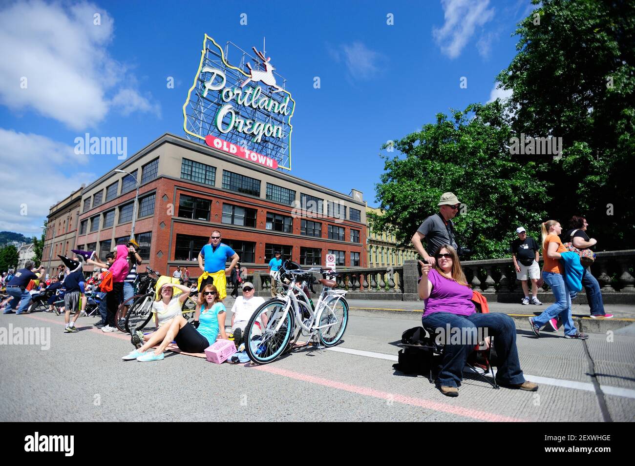 People sit on the Burnside Bridge in front of the famous Portland ...