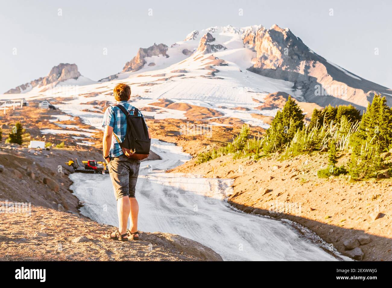 White man hiking in the snow top Mountains in the Summer. Route to the ...