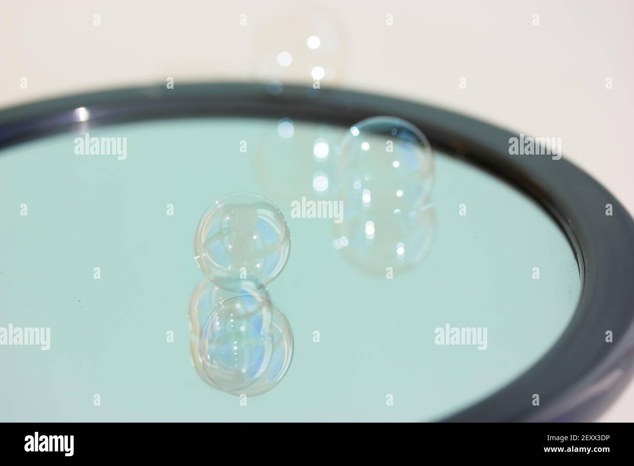 Soap bubbles on the surface of a round mirror. Reflection of soap ...
