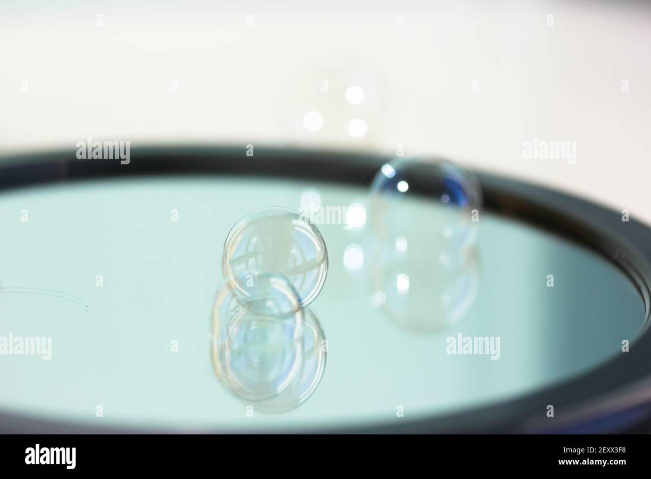 Soap bubbles on the surface of a round mirror. Reflection of soap ...