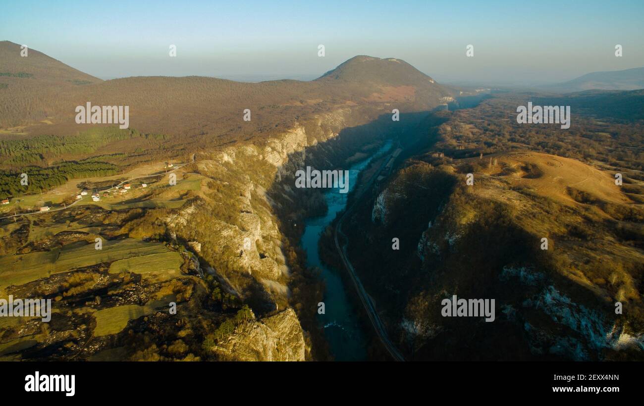 A blue-water river surrounded by canyons and hills in a rural area ...