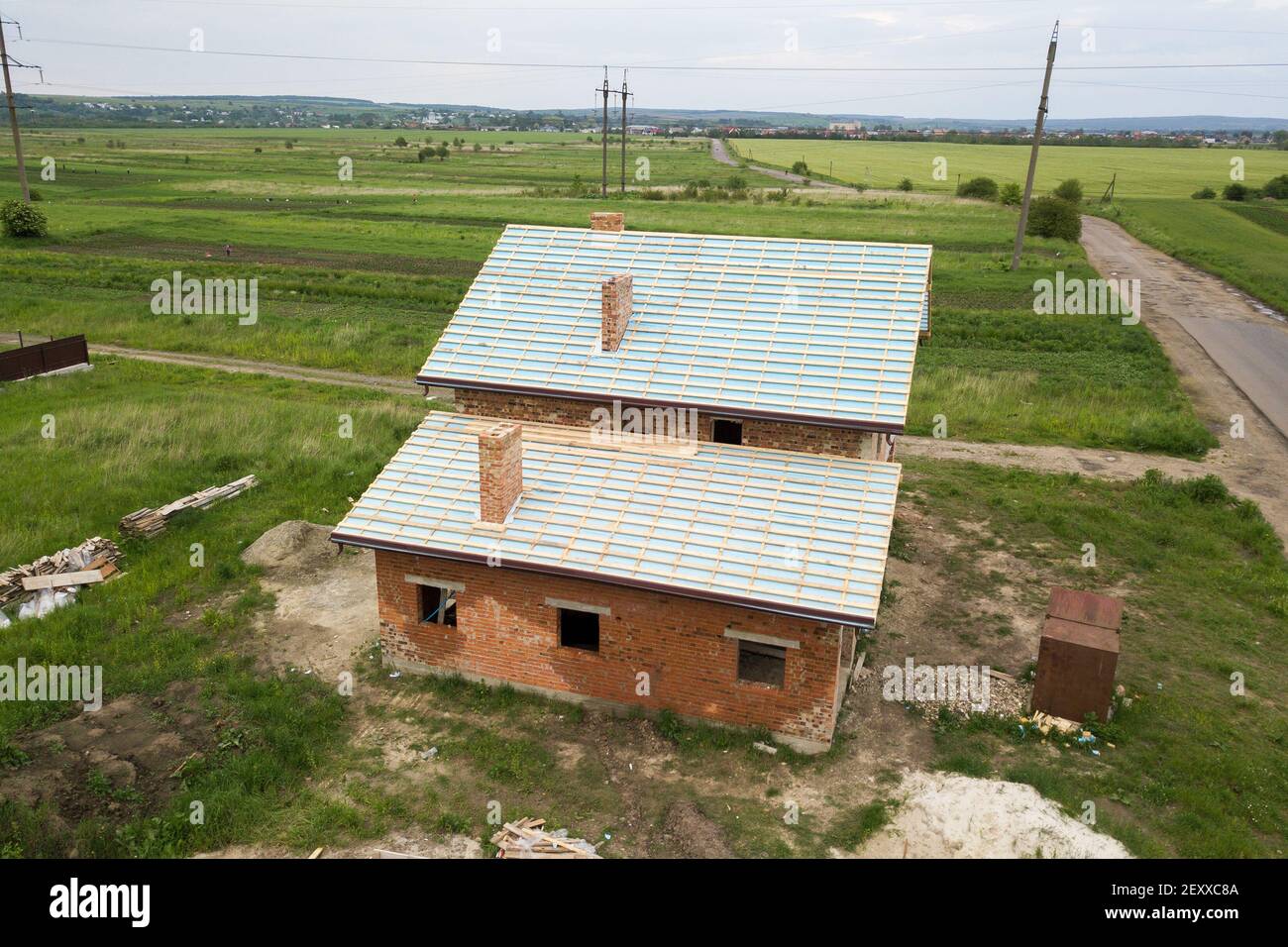 Aerial view of a brick house with wooden roof frame under construction ...