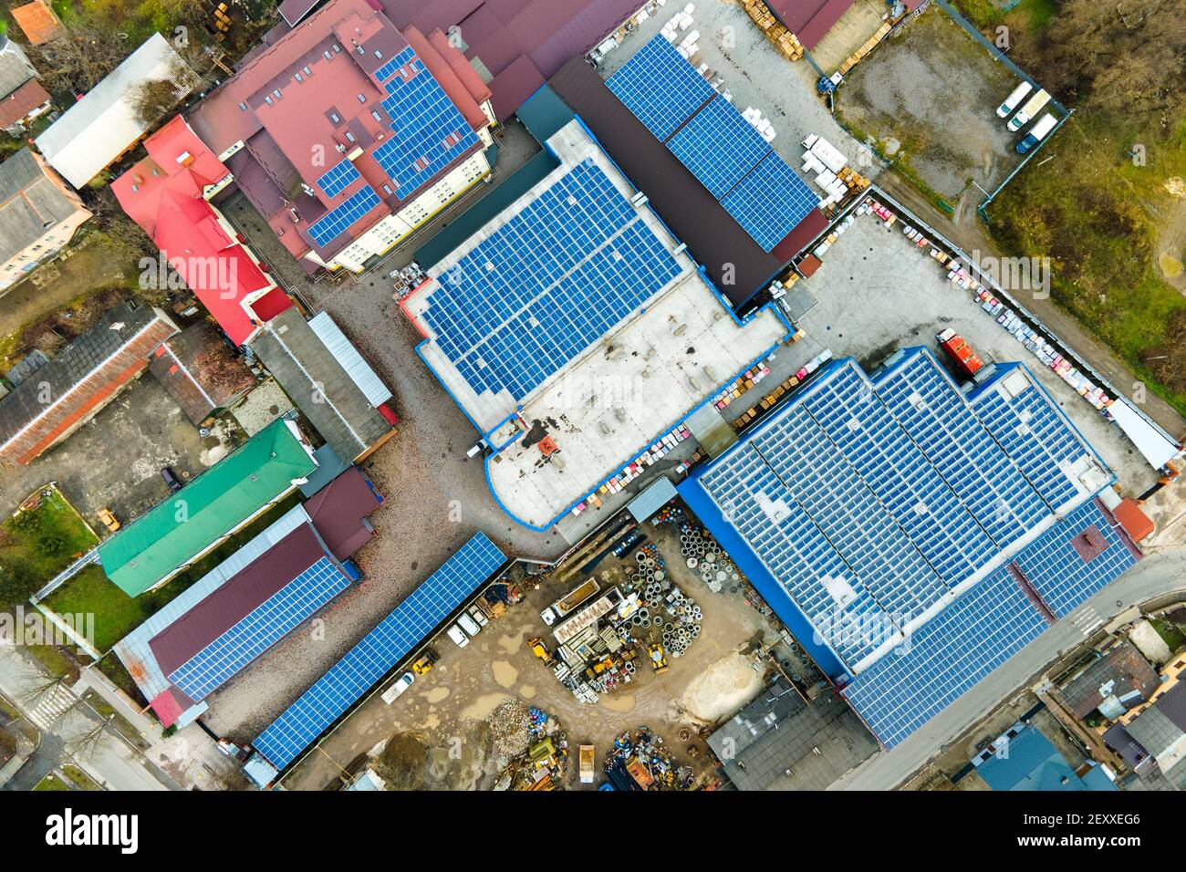 Blue photovoltaic solar panels mounted on industrial building roof for ...