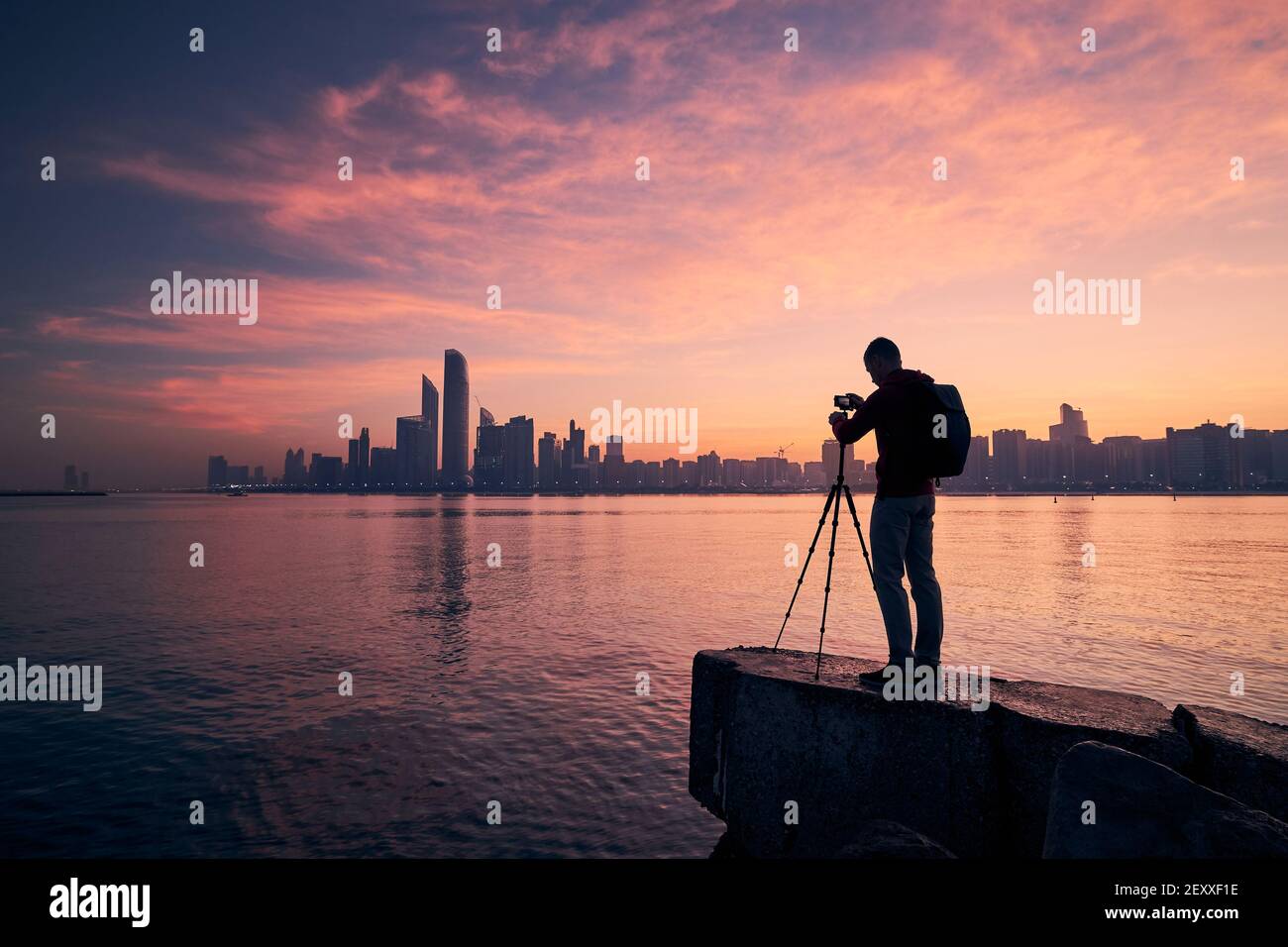 Silhouette of photographer with tripod. Young man photographing urban ...