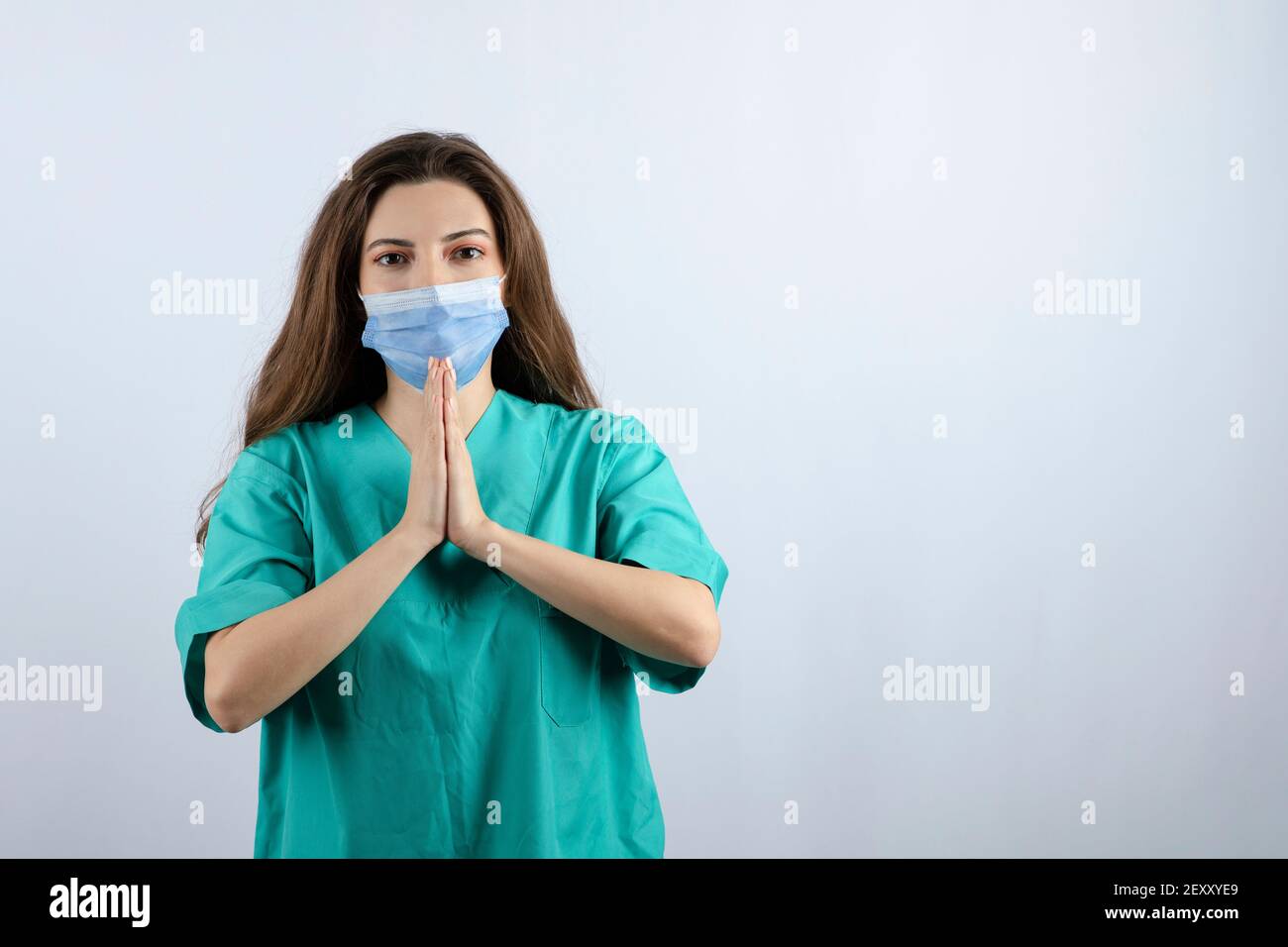 Young beautiful nurse in green uniform wearing a medical mask Stock ...