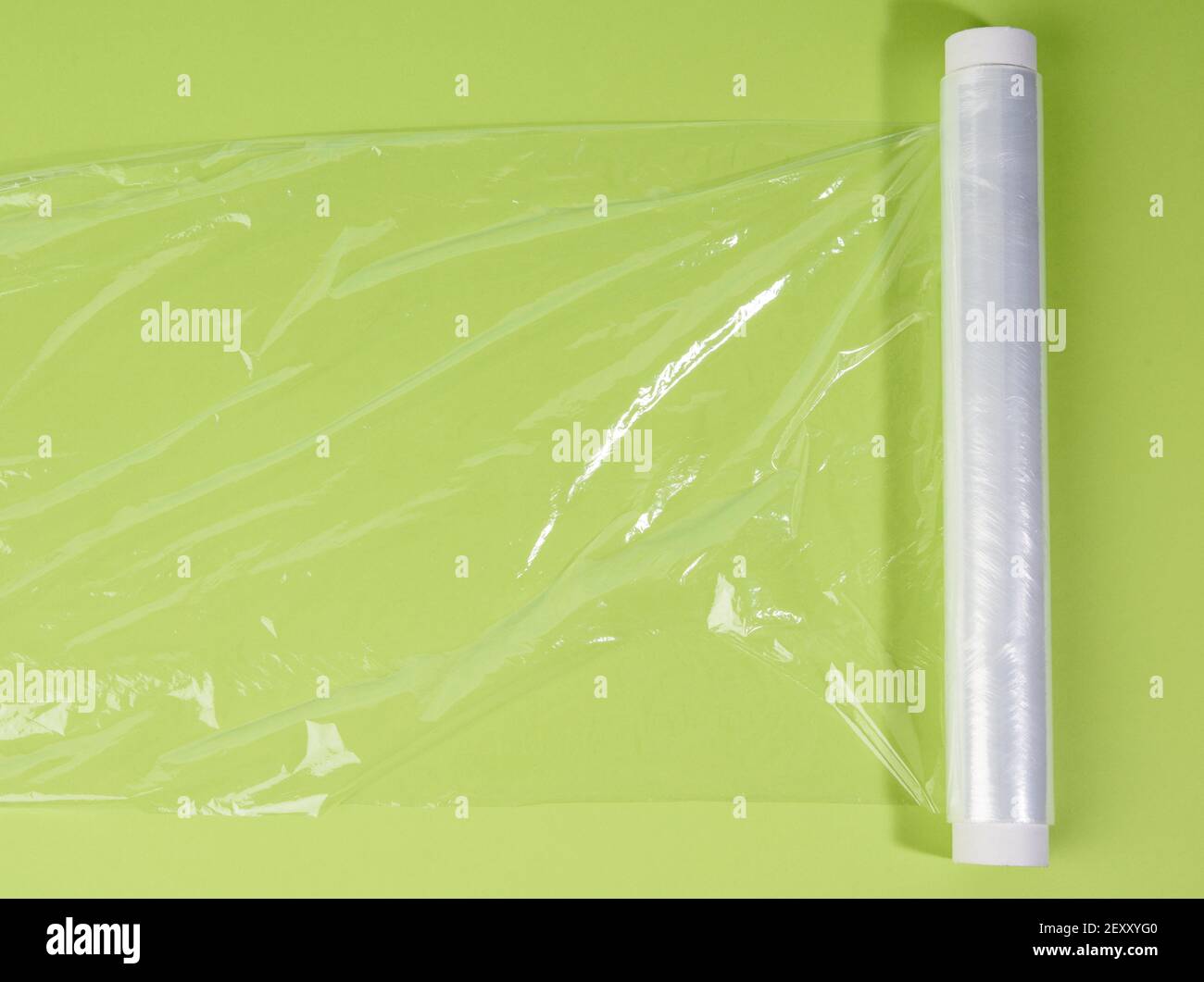 roll of transparent cling film for packaging ona green background, top ...