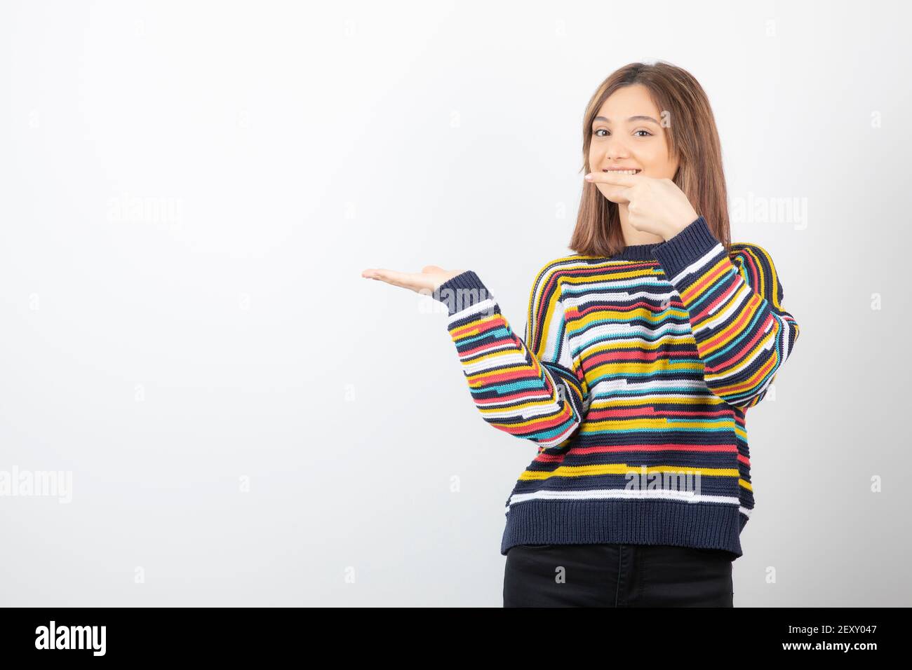 Portrait photo of a young woman model pointing at hand Stock Photo - Alamy