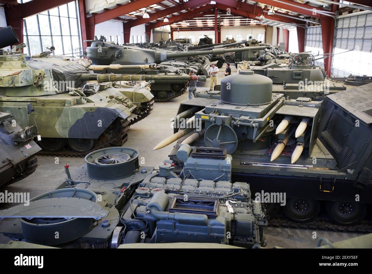 Military vehicles fill one of several large buildings, part of the ...