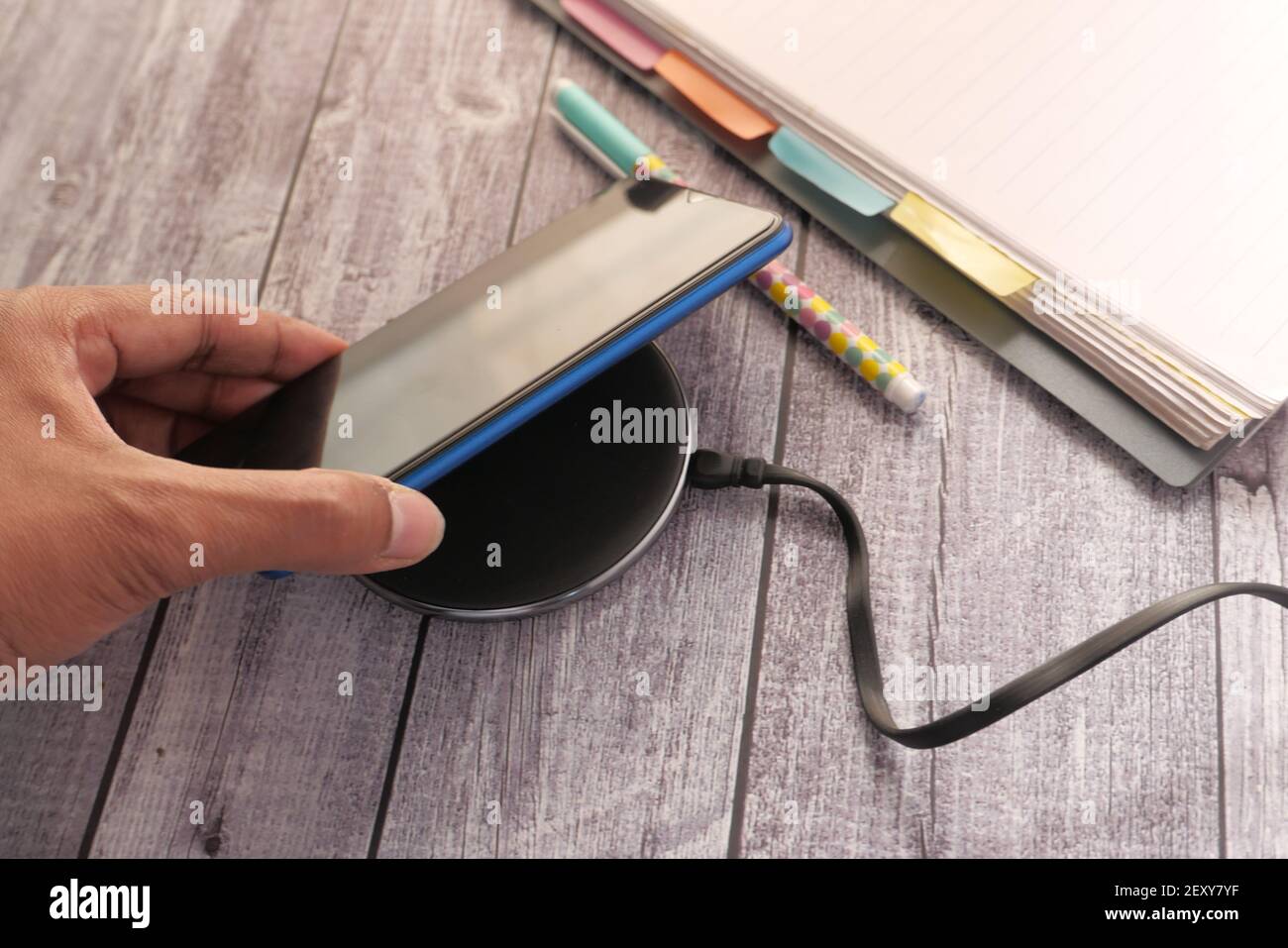 charging Smartphone using Wireless Charging Pad, top view Stock Photo ...