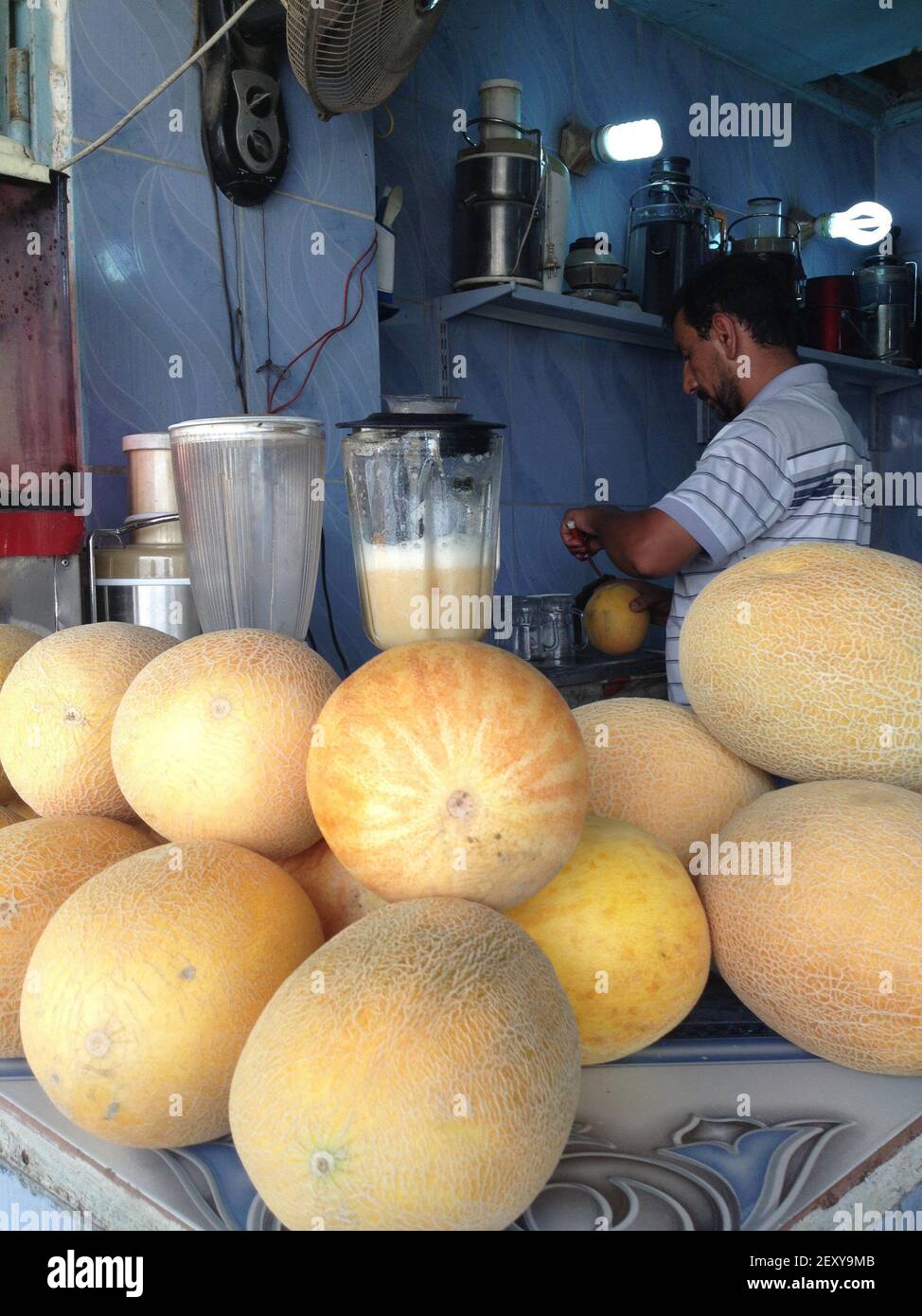 A vendor in Baghdad chops up cantaloupe to make fresh juice. Despite ...