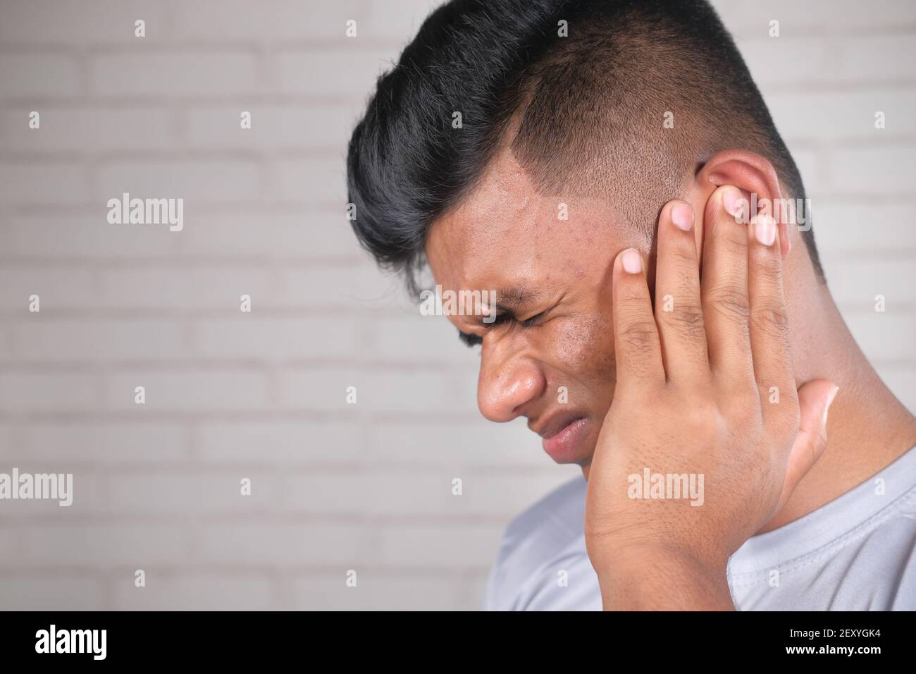 side view of young man suffering pain in ear Stock Photo - Alamy