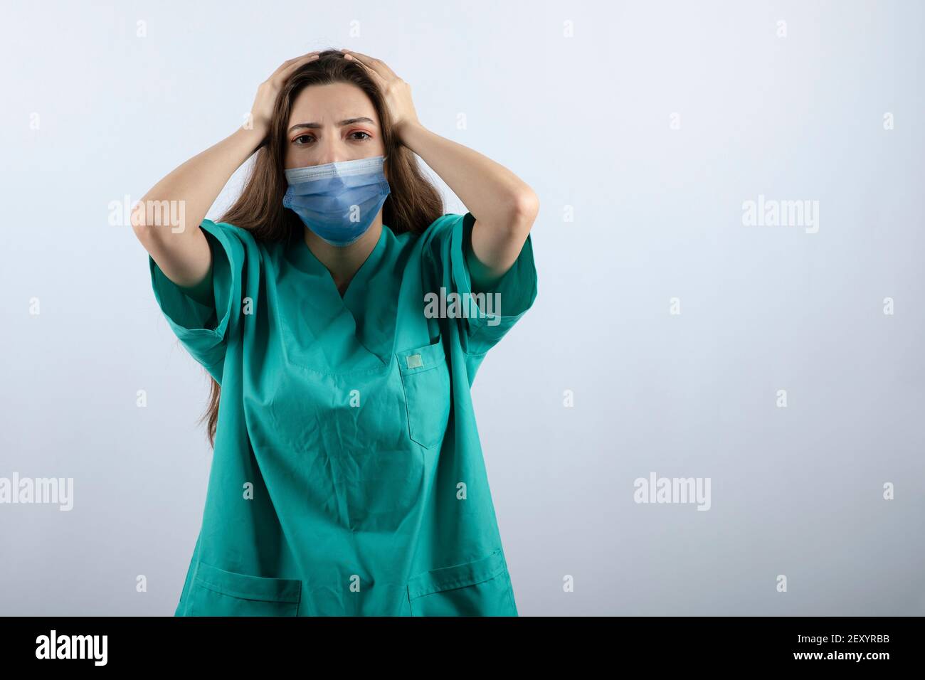 Young beautiful nurse in green uniform wearing a medical mask Stock ...