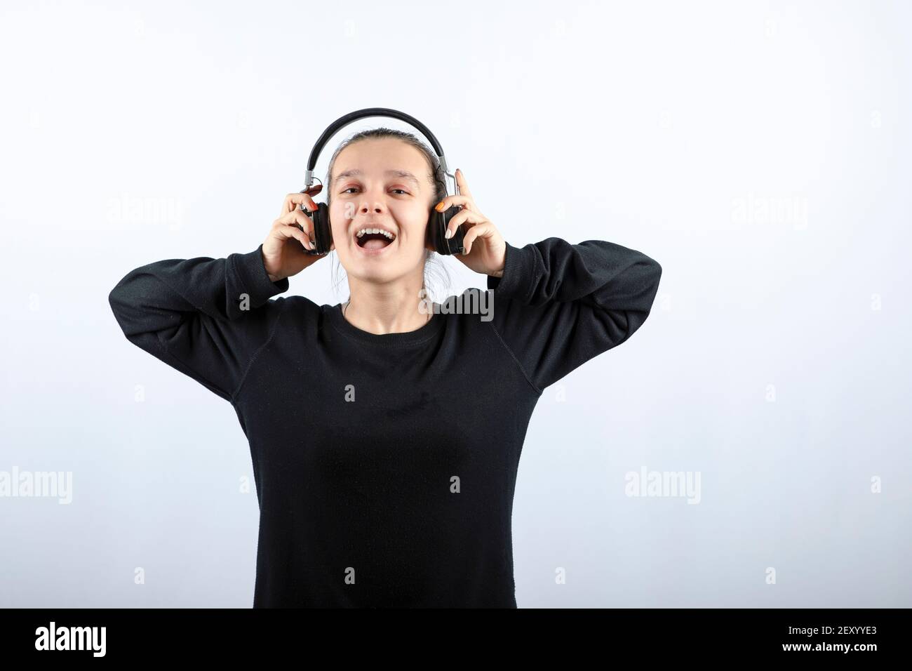 Photo of a young girl model listening music in headphones Stock Photo ...