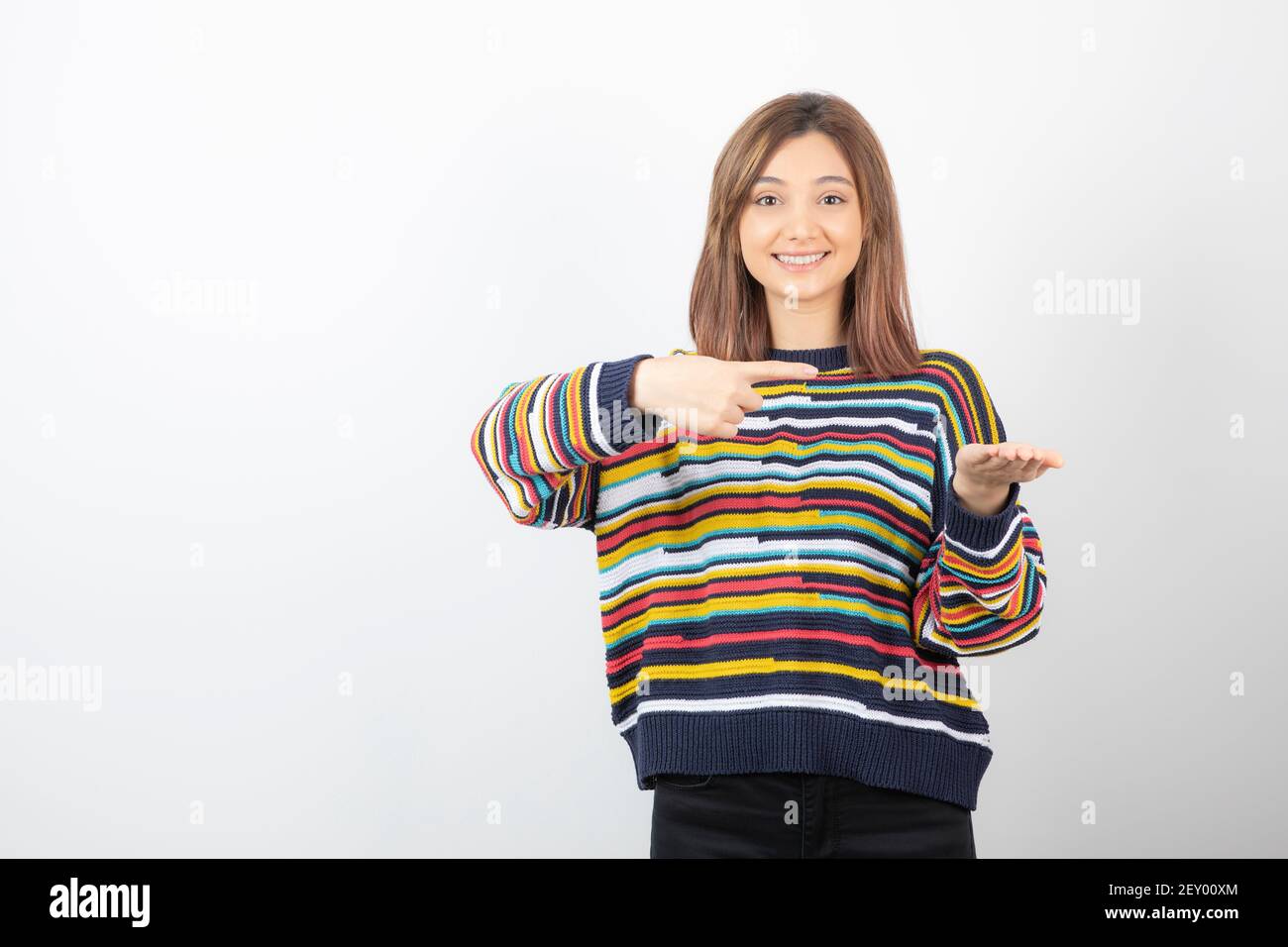 Portrait photo of a young woman model pointing at hand Stock Photo - Alamy