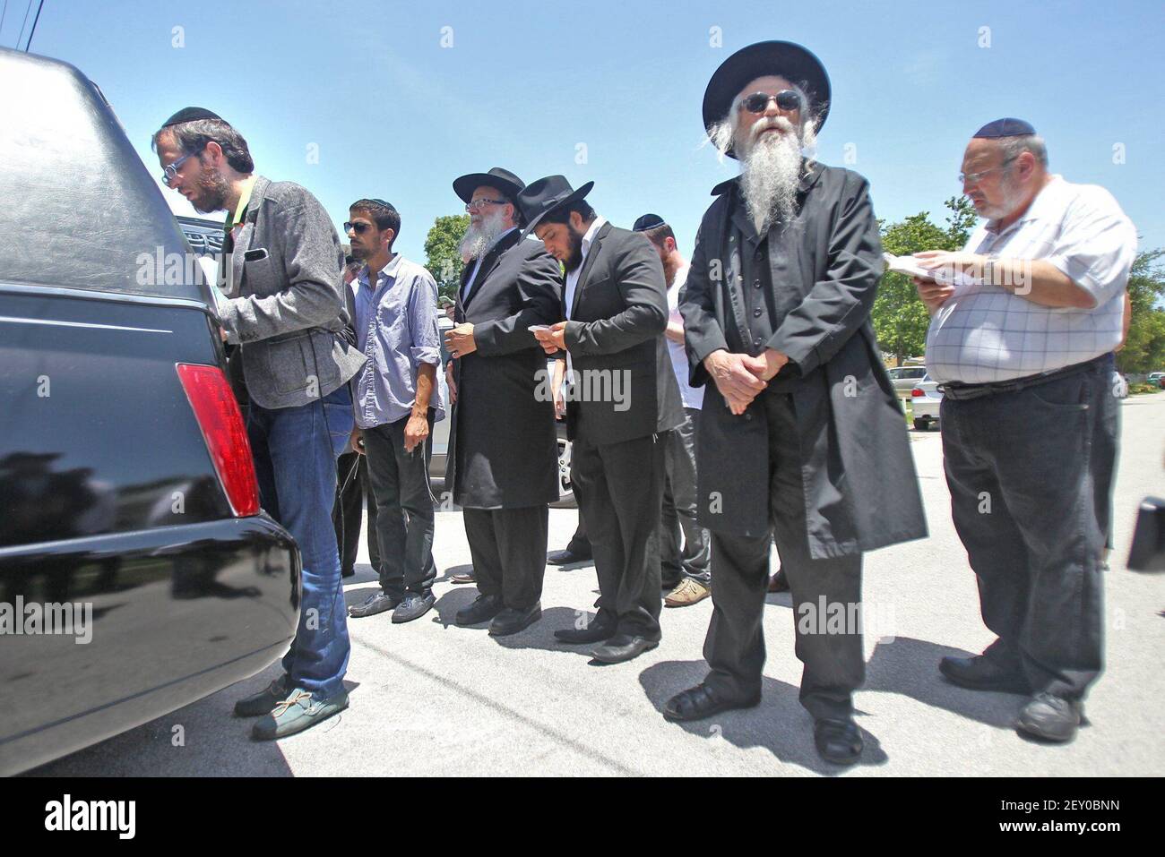 Izzy, far left, prays alongside several rabbis over his father-in-law ...