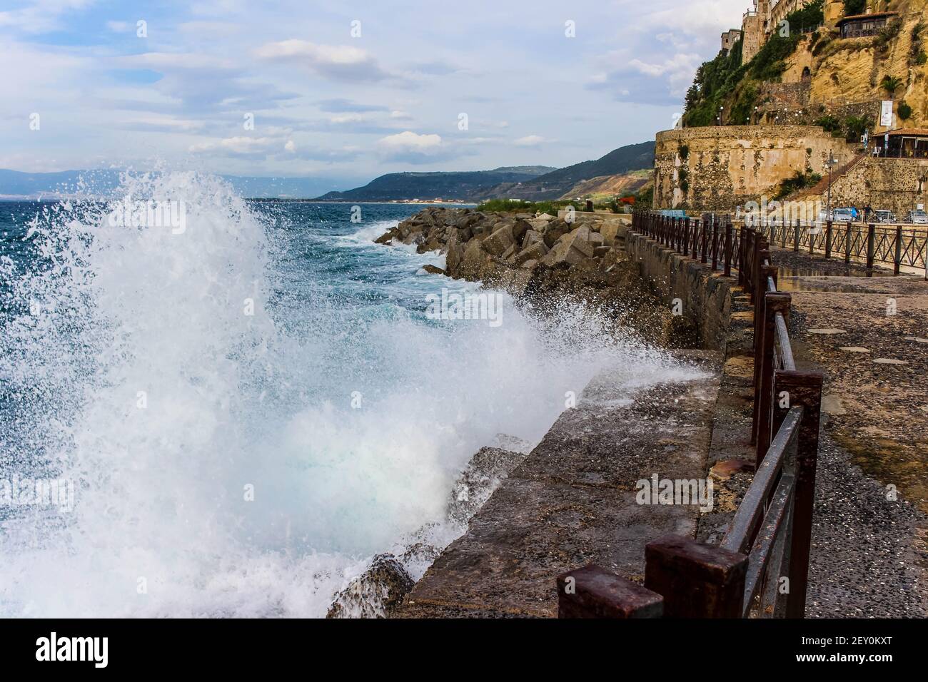 pavement along teh ocean with waves and blue sky Stock Photo - Alamy