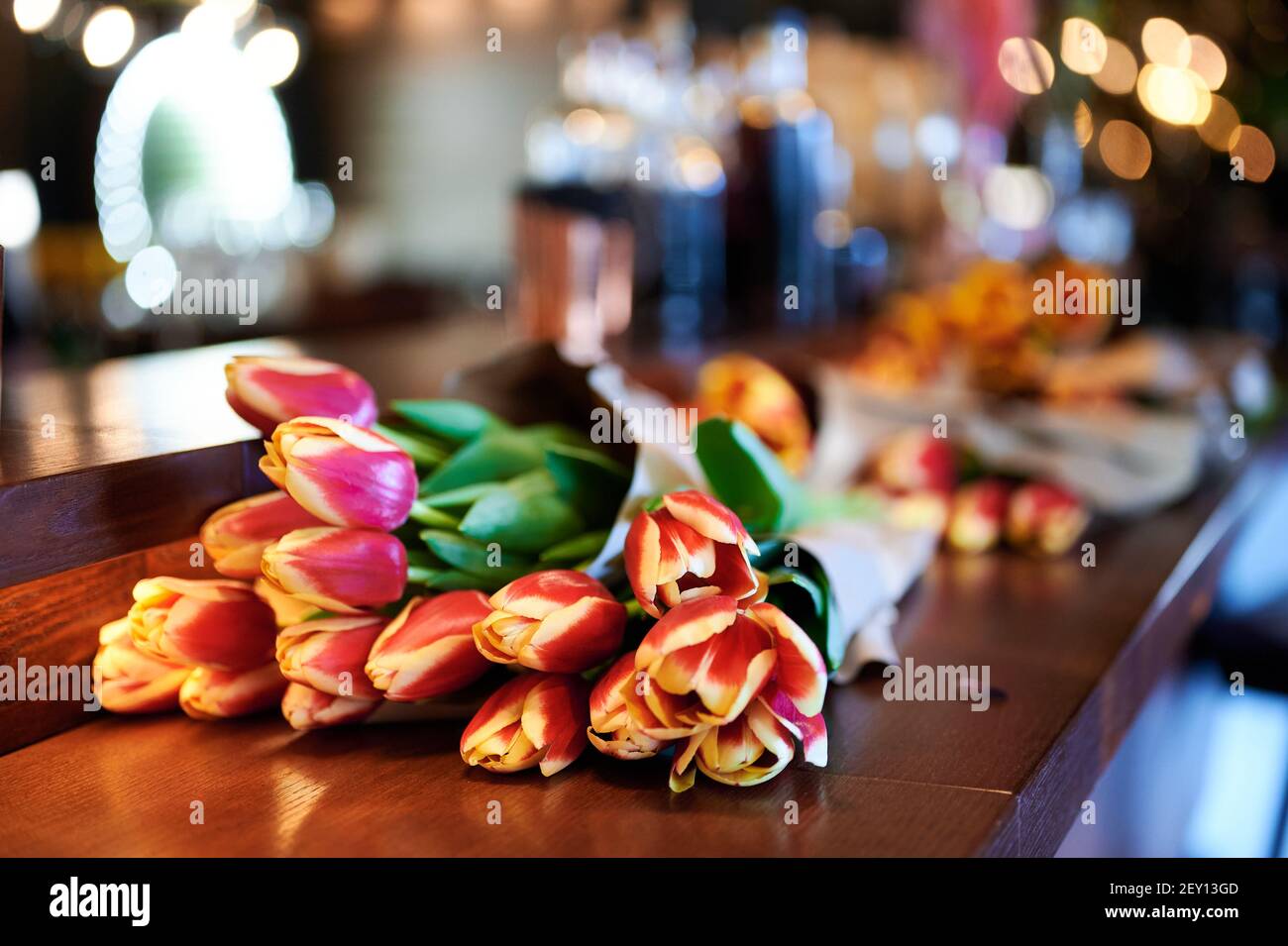 A bouquet of red and yellow Tulips lies on the bar counter in the ...