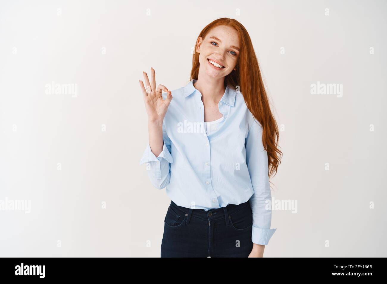 Girl with ginger hair showing OK sign and smiling, recommending your ...