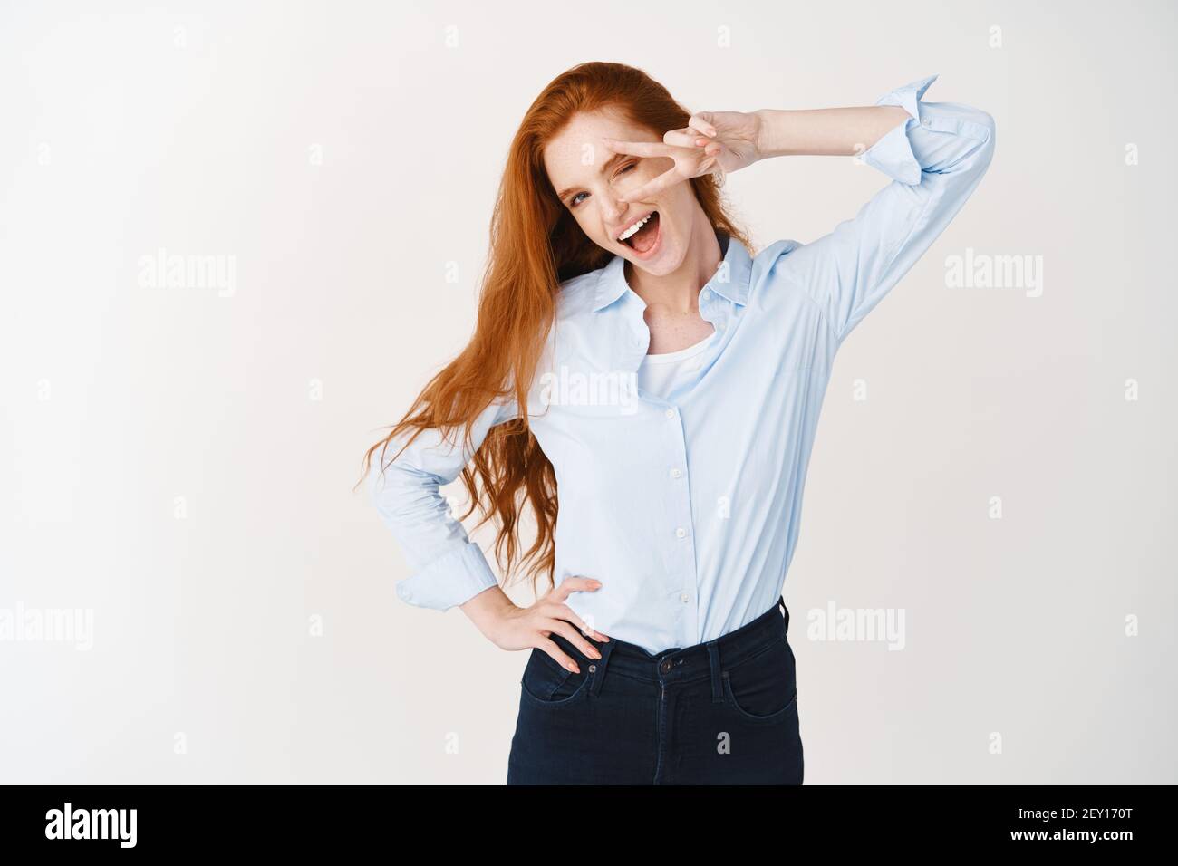 Image of young ginger girl in blue shirt showing peace sign isolated ...